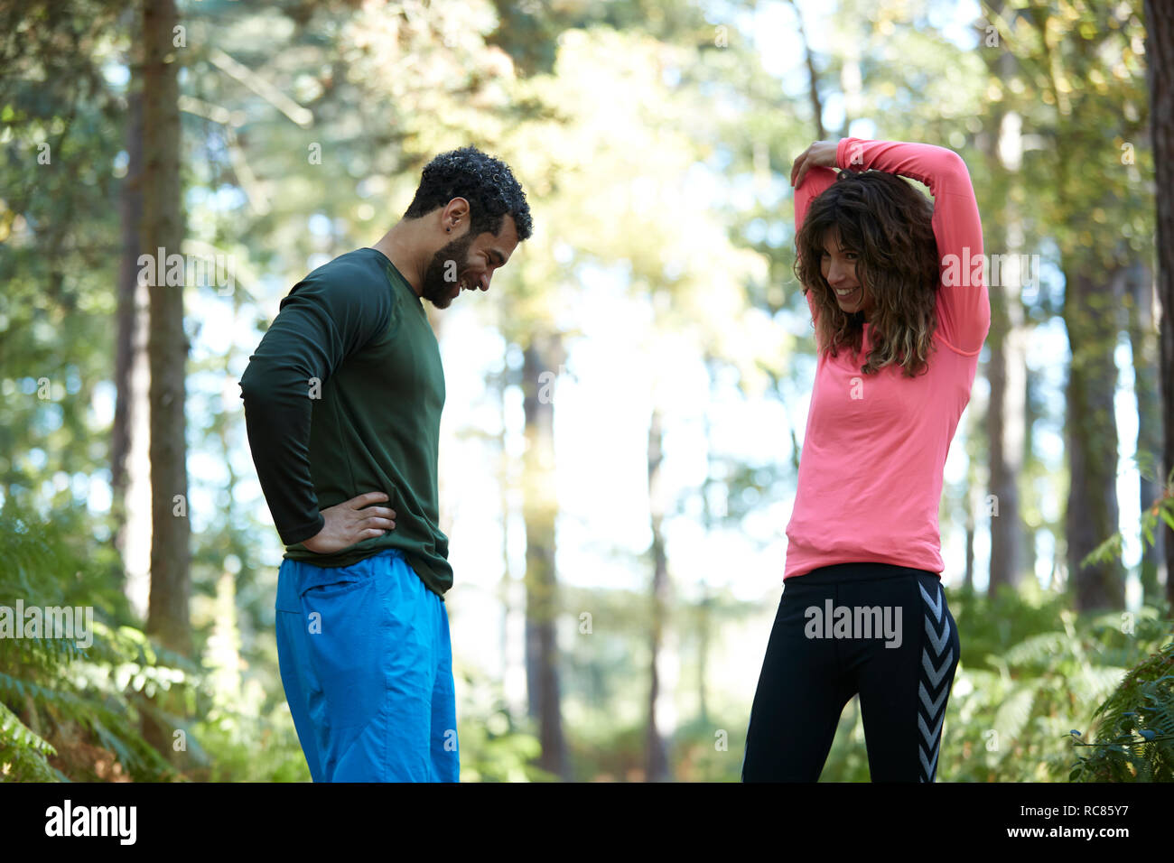Male and female runners taking a break in forest Stock Photo - Alamy