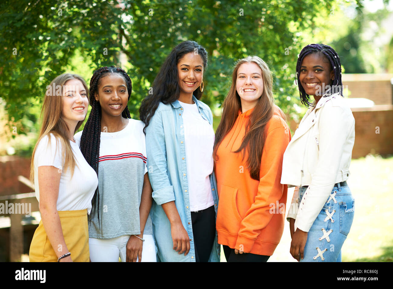 Five young women, higher education students on college campus, portrait ...