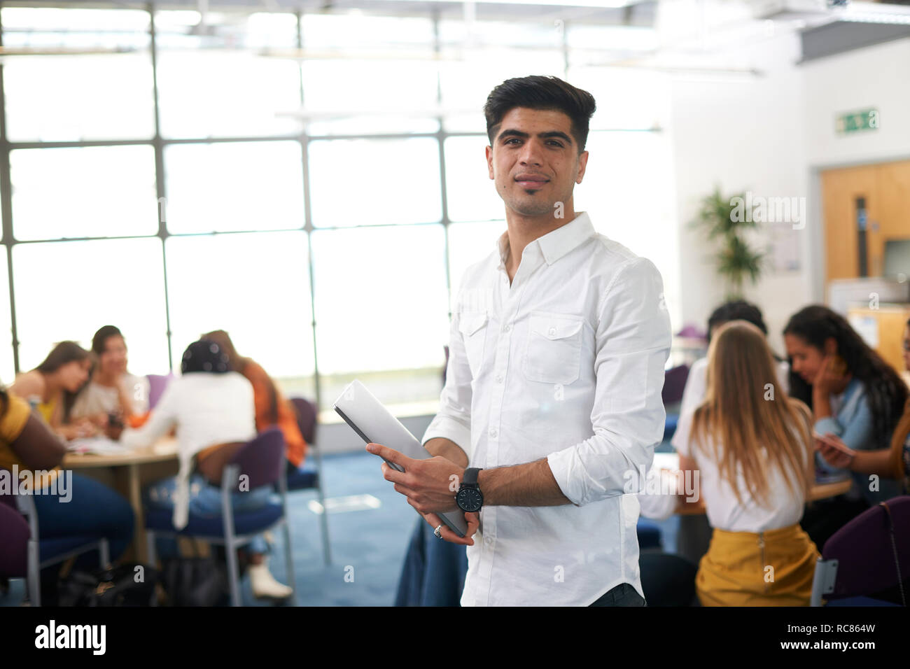 Young male higher education student in college classroom, portrait ...