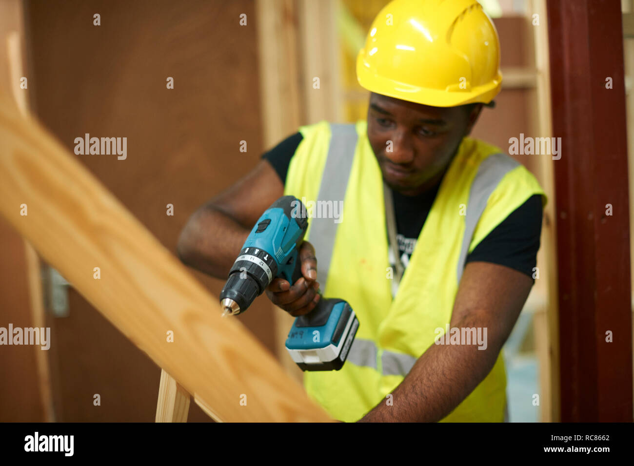 Male higher education student drilling wooden framework in college ...