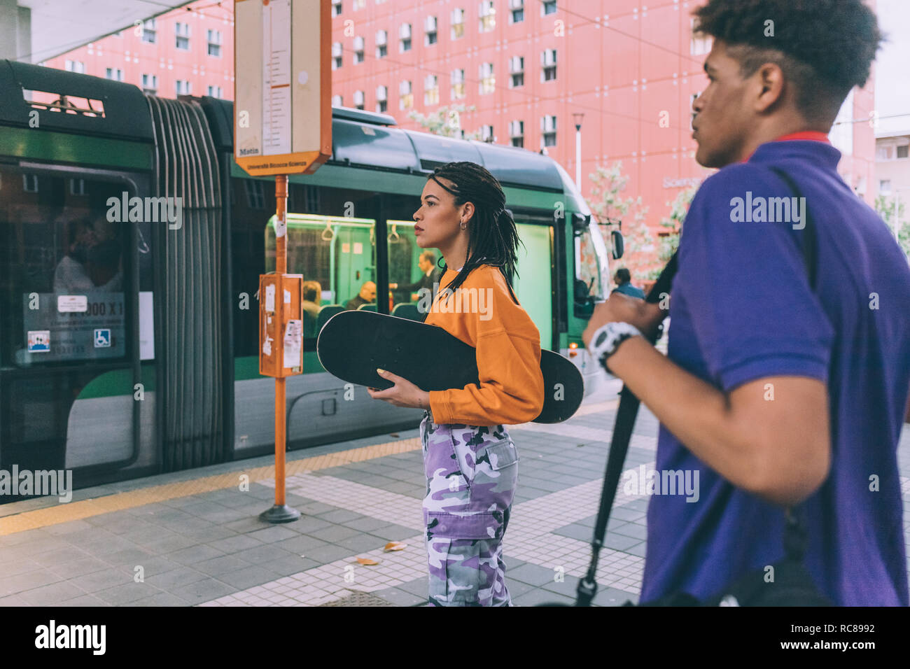 Brother and sister at tram stop, Milan, Italy Stock Photo - Alamy