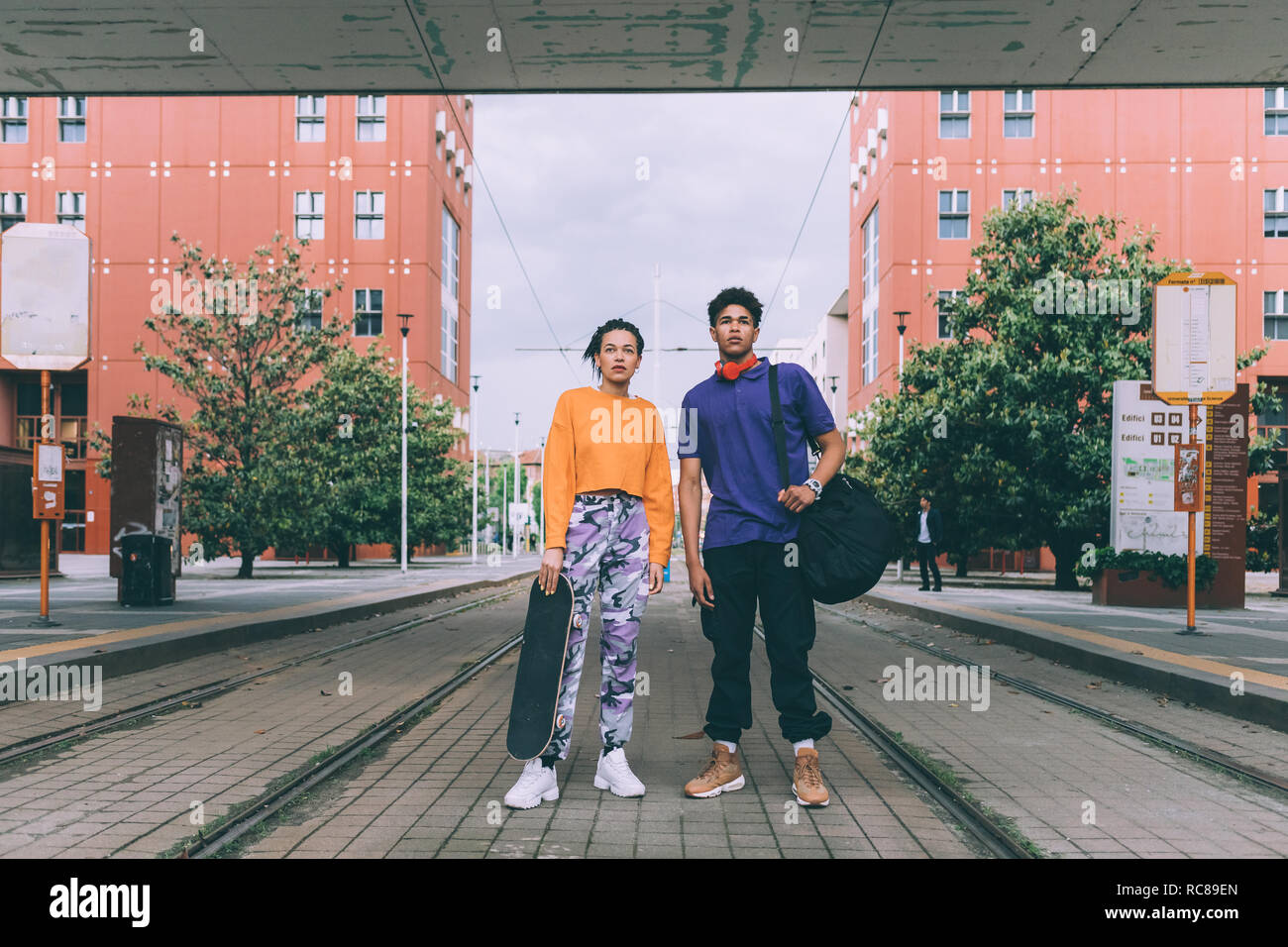 Brother and sister standing on tram tracks, Milan, Italy Stock Photo ...