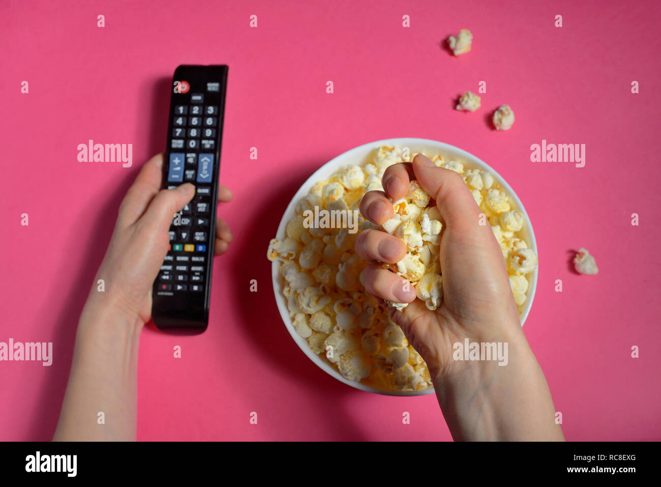 Top view of hands holding remote controller and popcorn bucket isolated ...