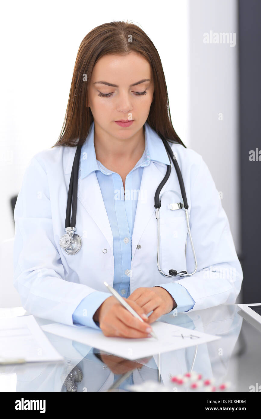 Doctor woman at work. Portrait of female physician filling up medical ...