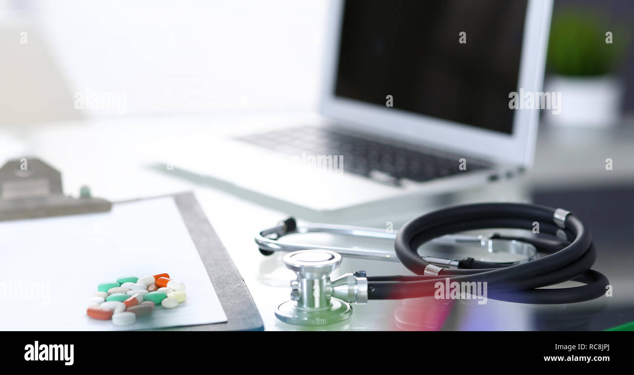 Stethoscope, prescription medical form lying on glass table with laptop ...