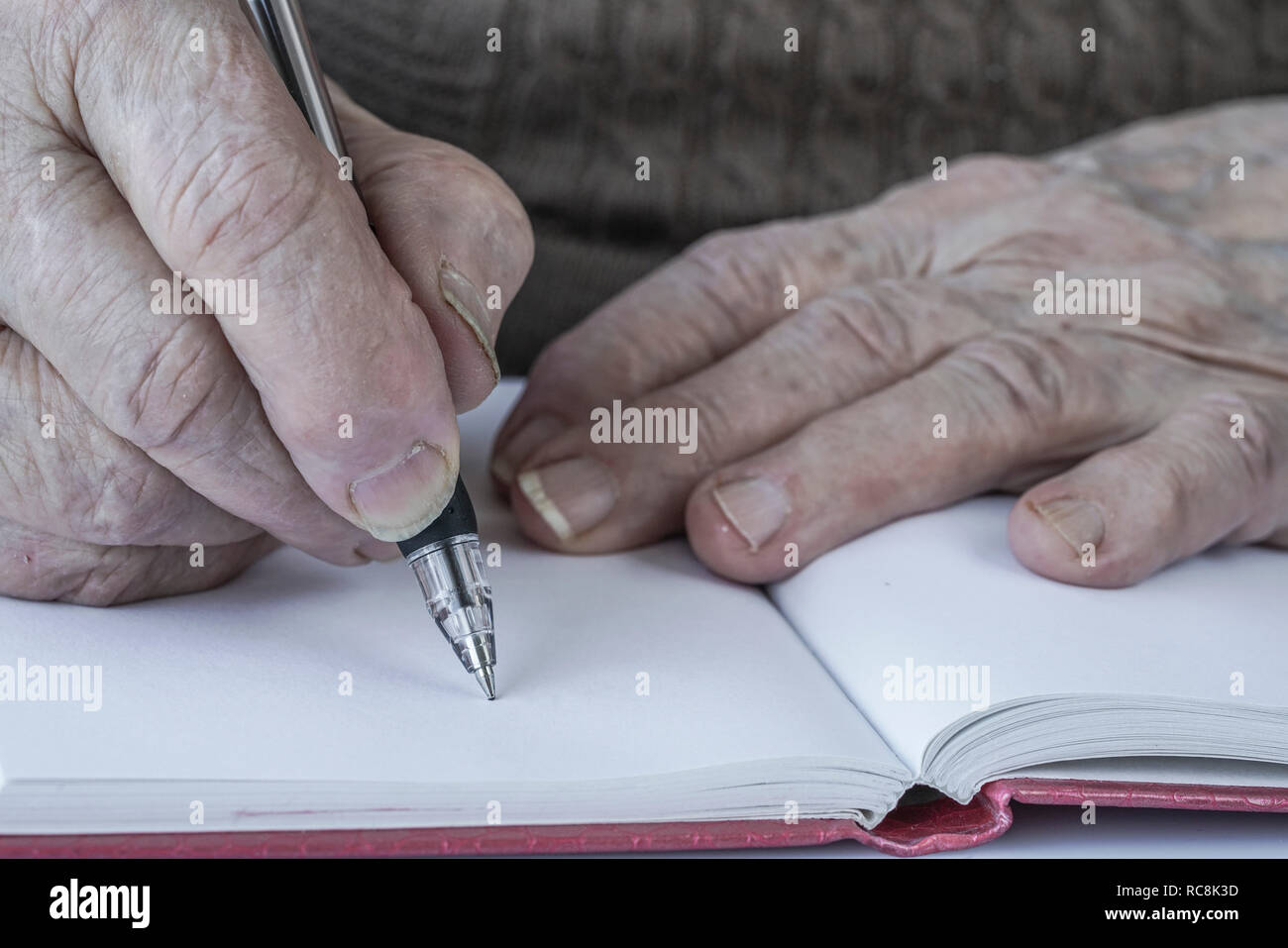 closeup wrinkled hands of a person writing on paper Stock Photo - Alamy