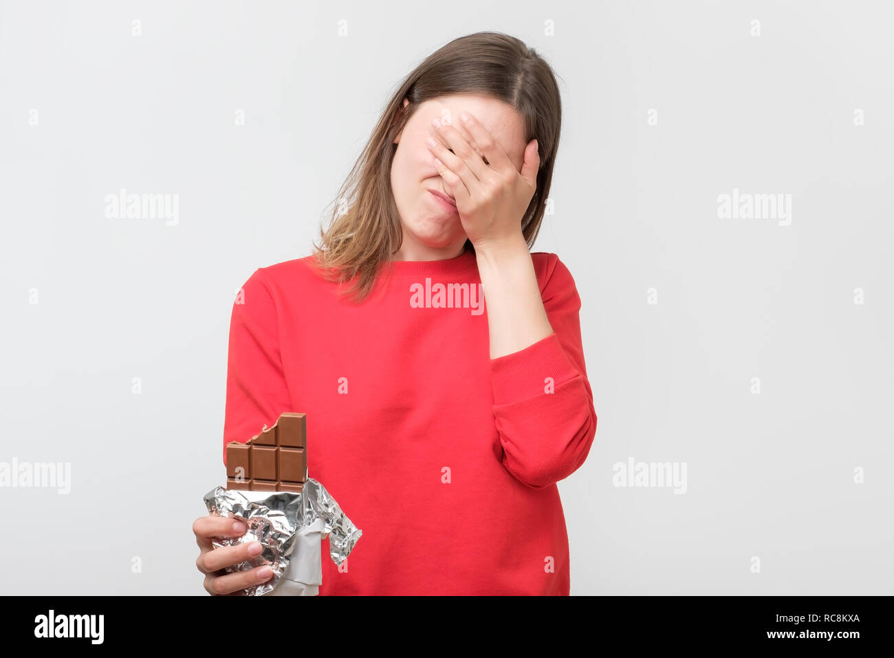 Sad young woman tired of diet restrictions holding sweet chocolate ...