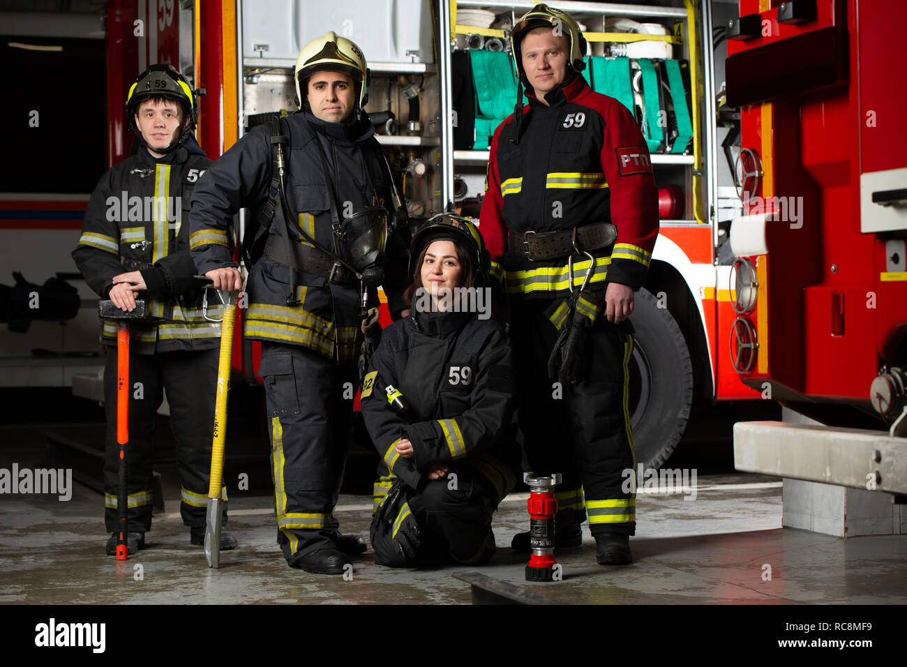 Image of three firemen men and woman near fire truck Stock Photo - Alamy