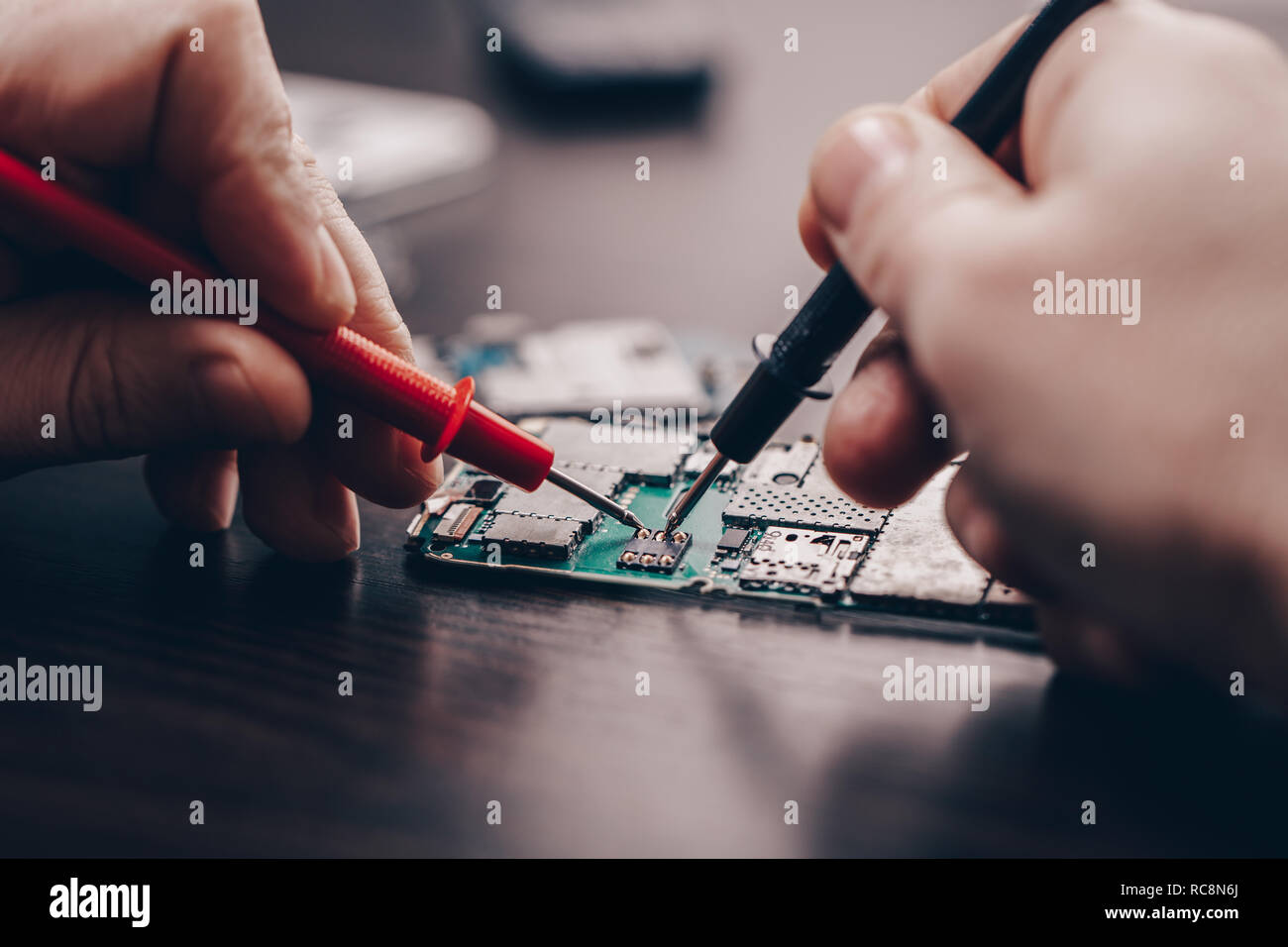 mobile phone repair, hands closeup on a wooden table Stock Photo - Alamy
