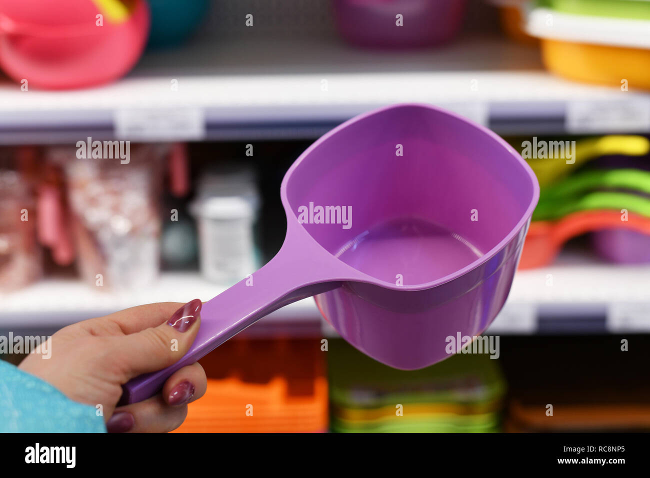 Plastic bucket for water in female hand on shop background Stock Photo ...