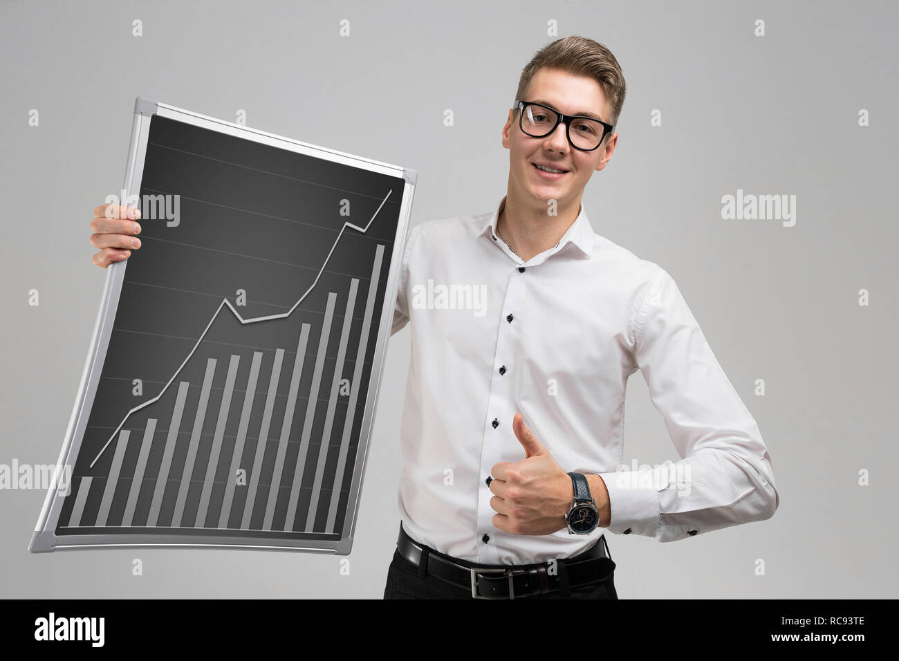 Young man shows class sign and keeps rising graph isolated on white ...