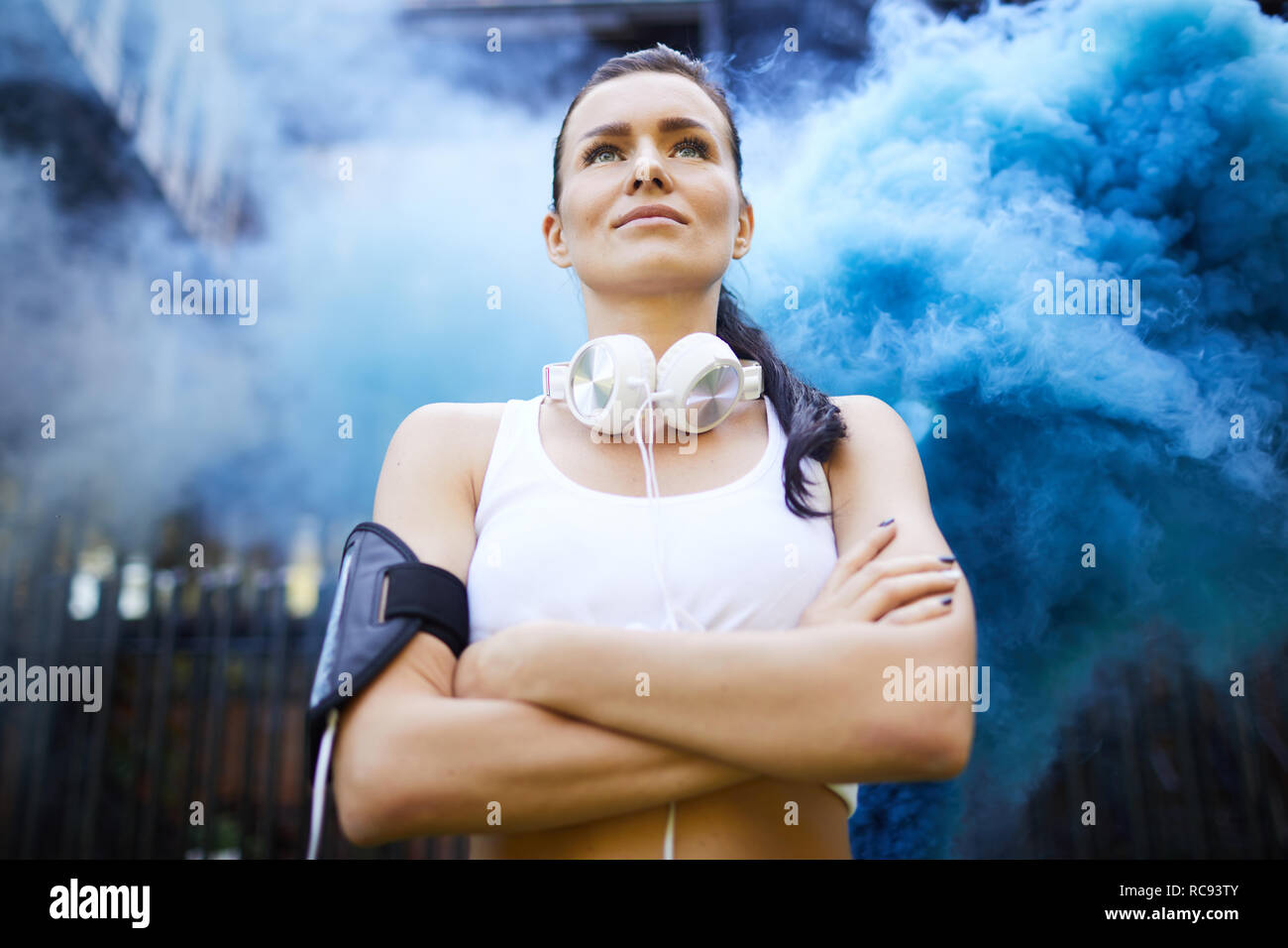 Content young woman standing in blue smoke Stock Photo - Alamy