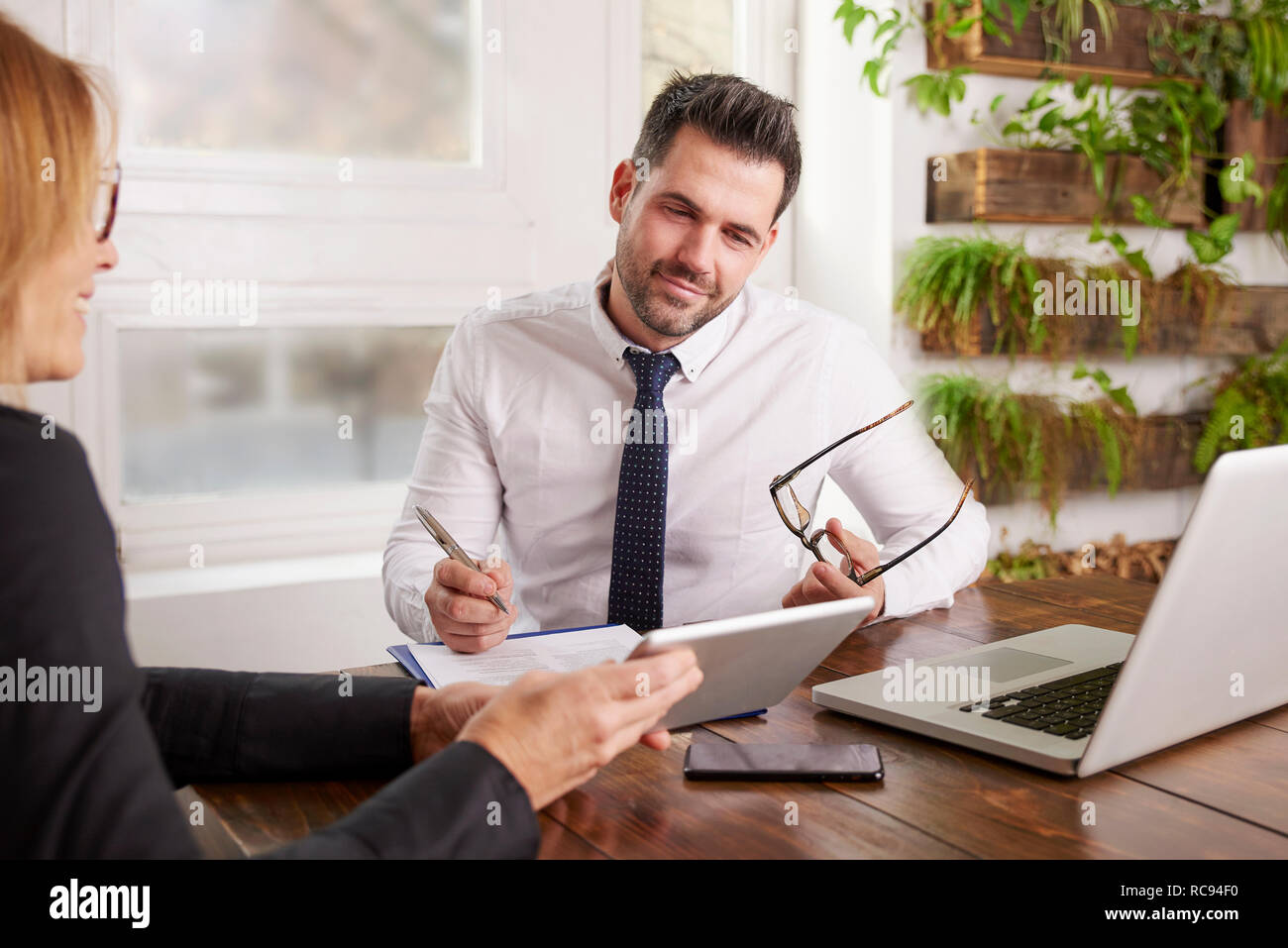 Shot of sales team working together on new project. Businessman sitting at office desk in front ...