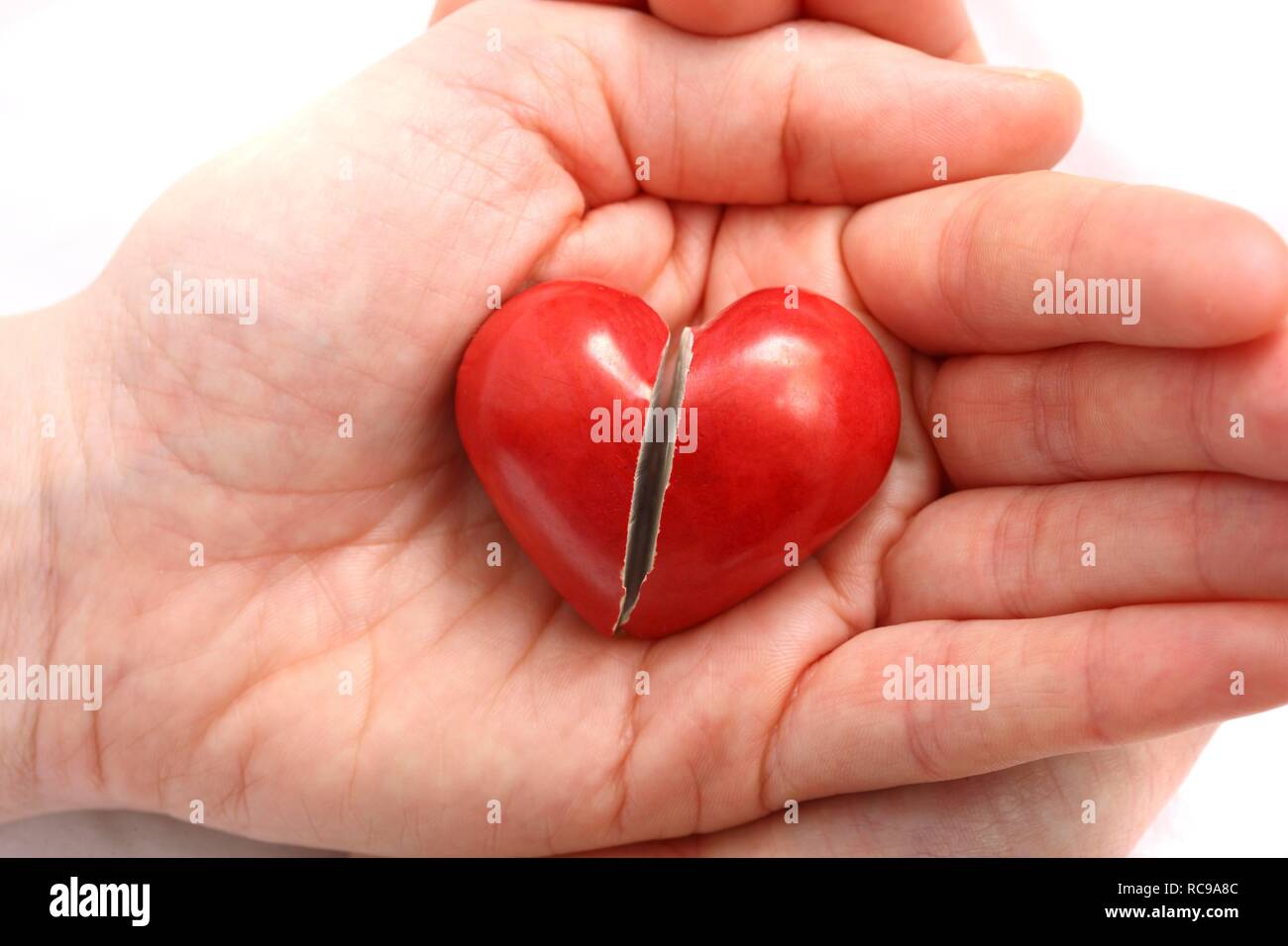 Hand holding a broken heart, symbolic image for heart disease, heart ...