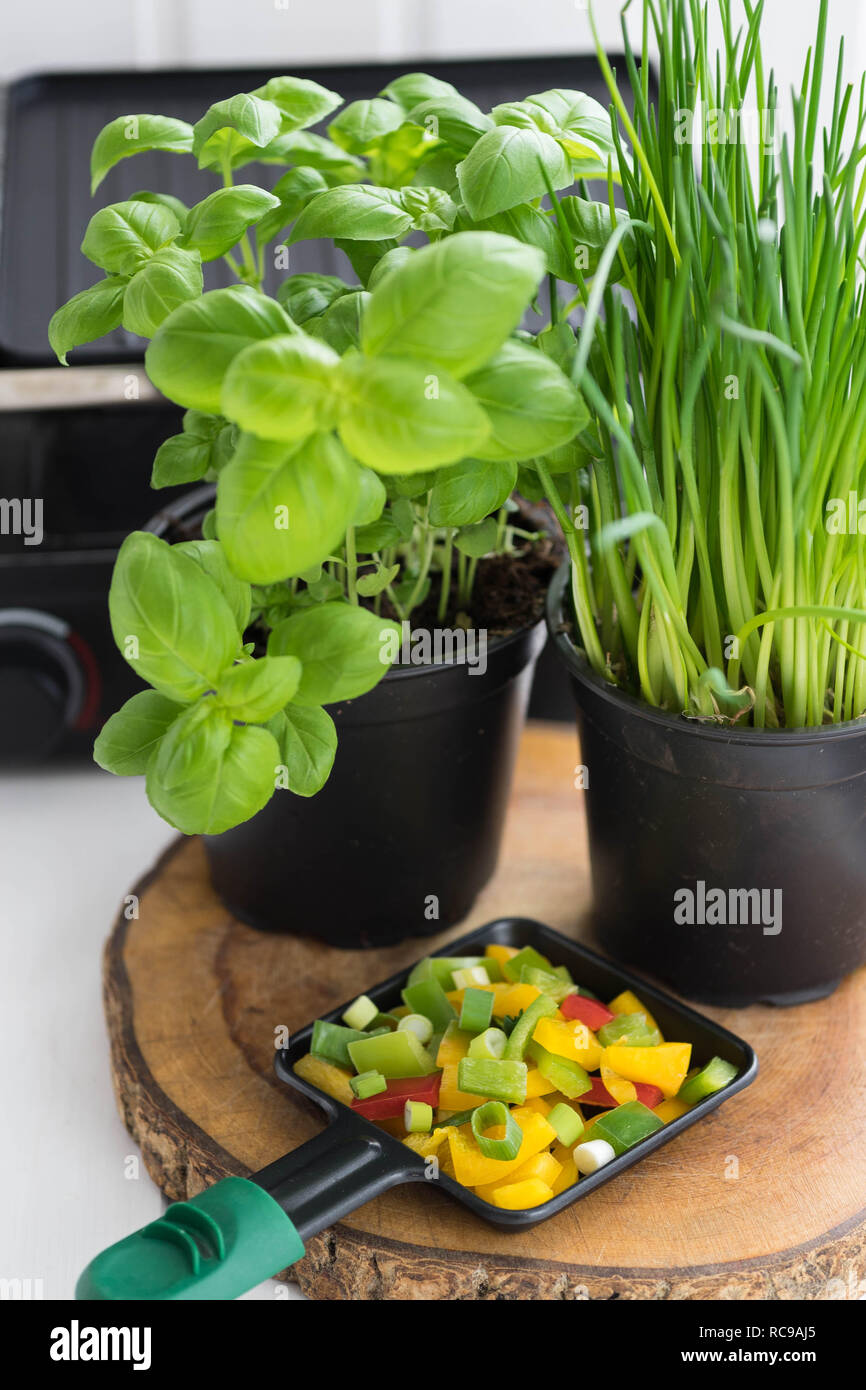 vegan raclette, raclette pan with finely chopped vegetables on a wooden ...