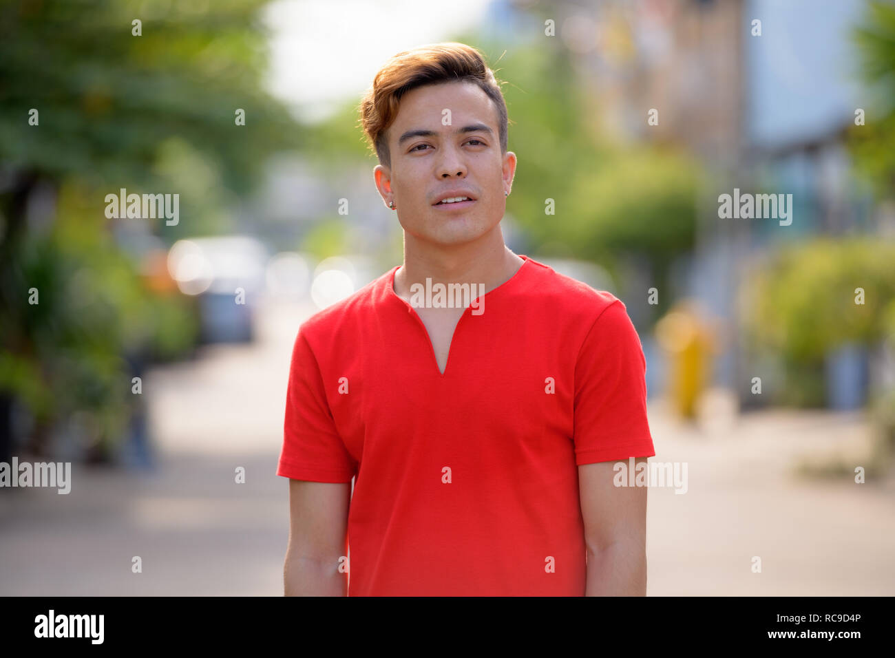 Young Asian man waiting and thinking in the streets outdoors Stock Photo - Alamy