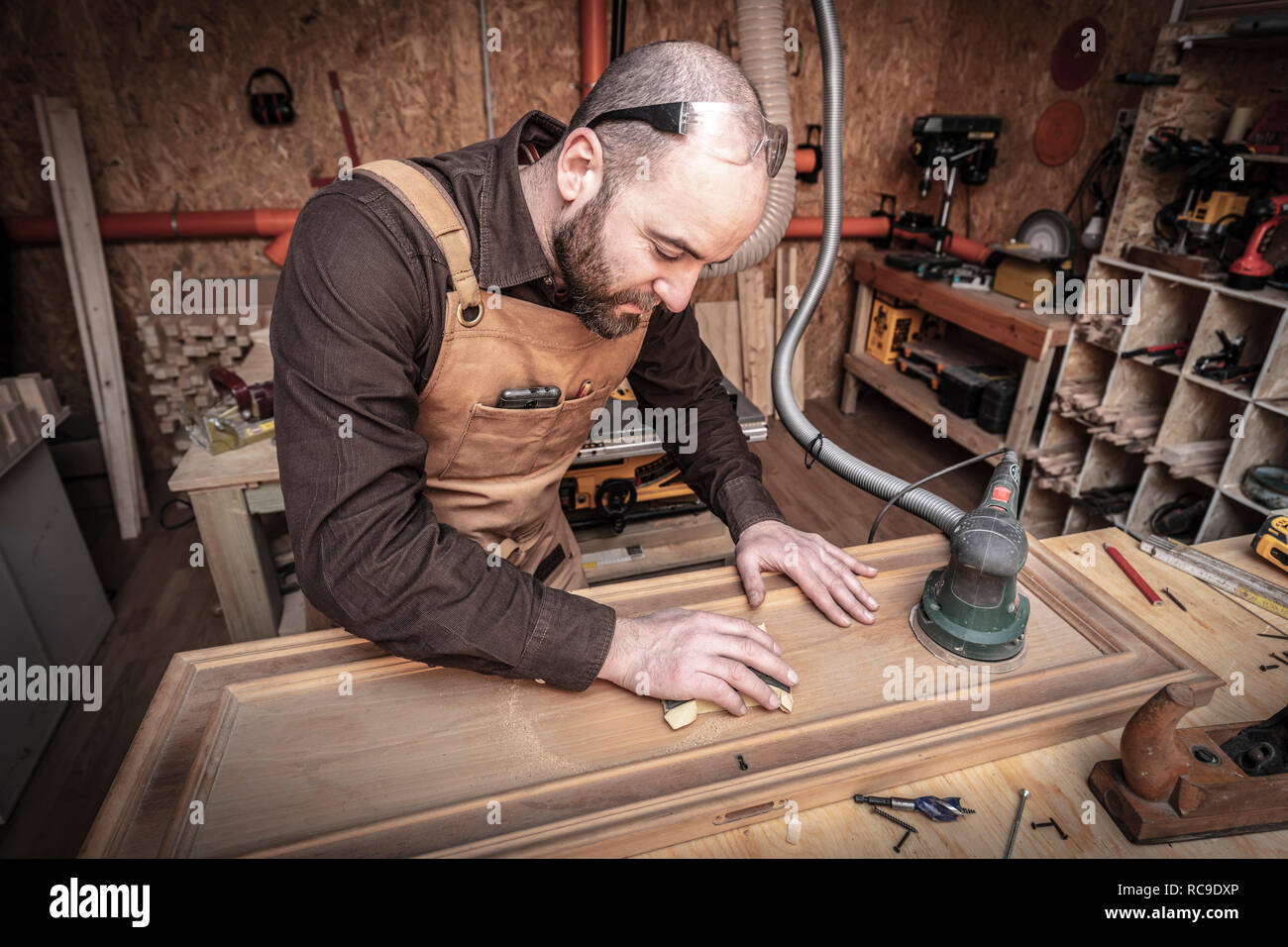 man sanding wood in his workshop Stock Photo - Alamy