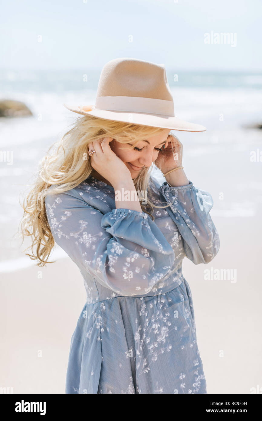 Young woman on windy beach with hands in hair hi-res stock photography ...