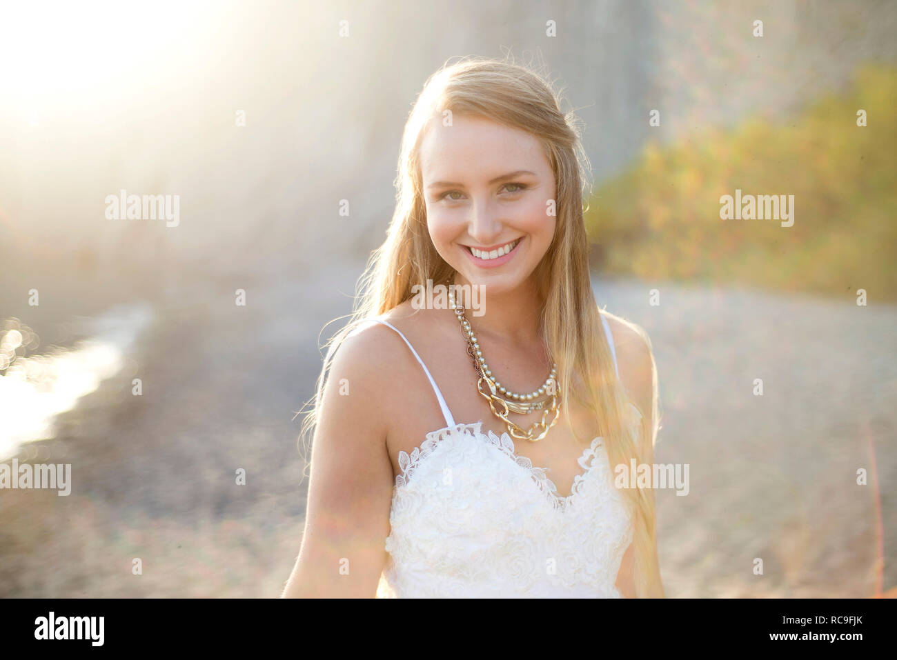 Bride in wedding dress on beach at sunset Stock Photo - Alamy