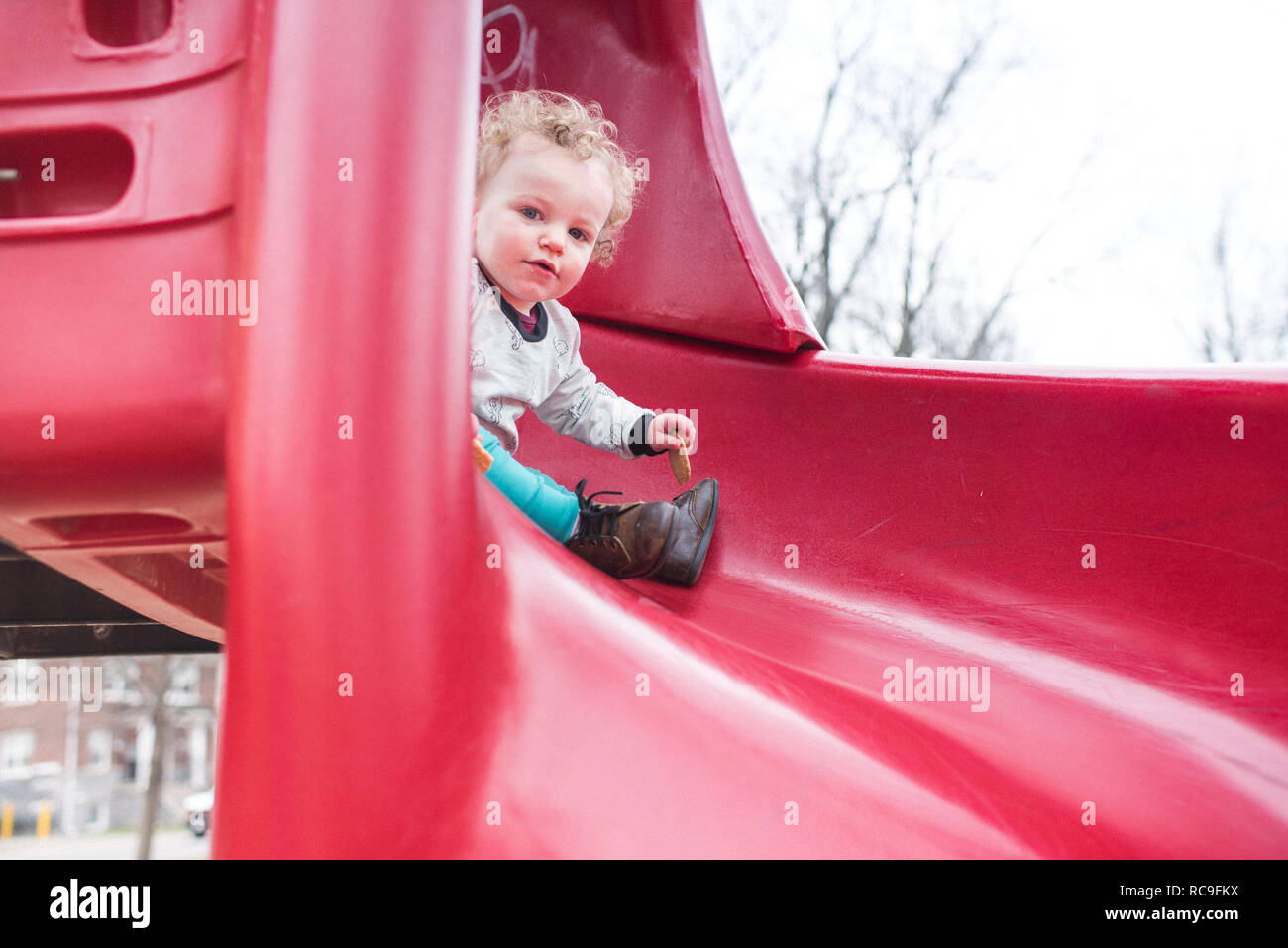 Toddler playing on slide Stock Photo - Alamy