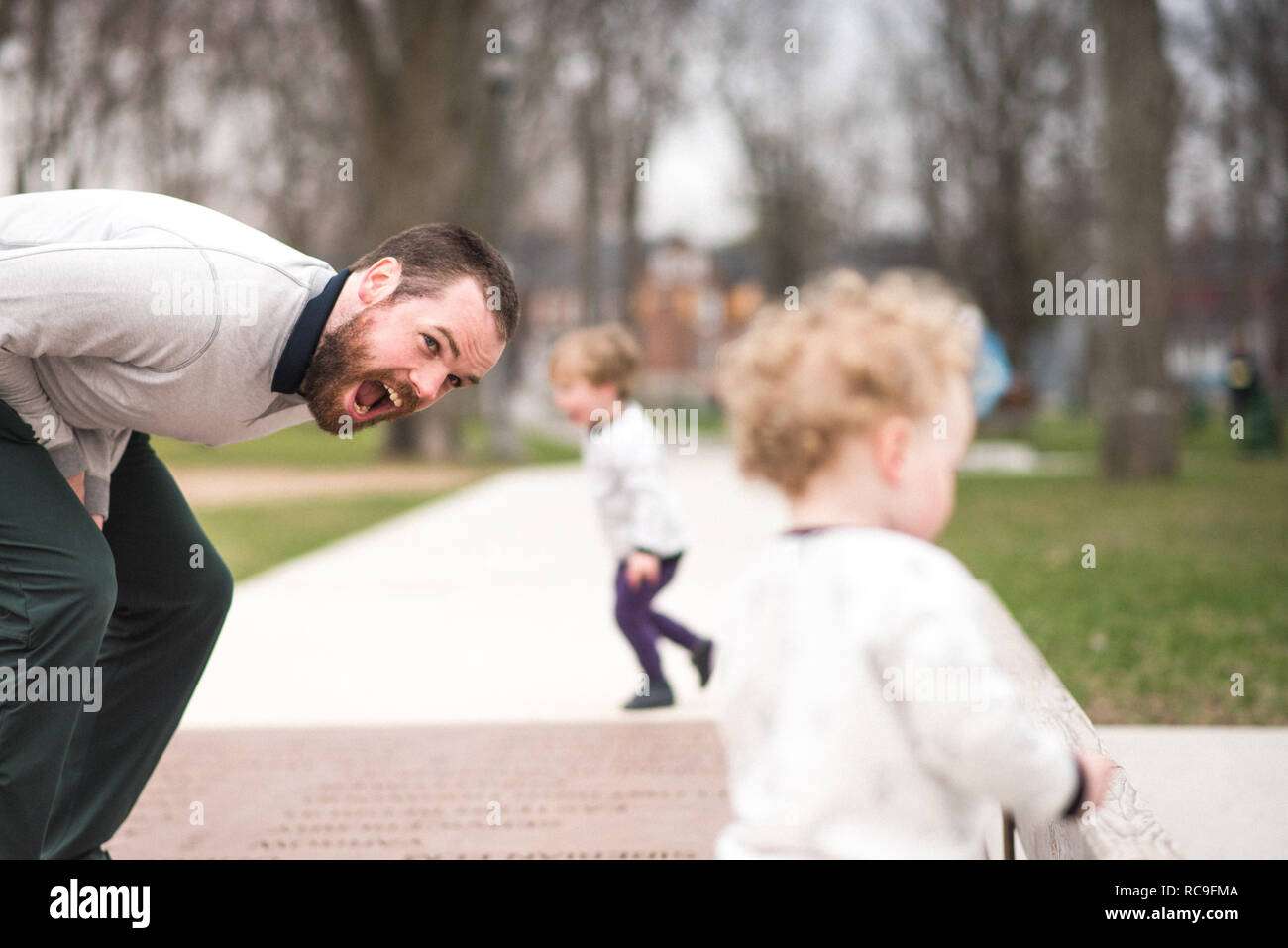 Father cheering up son in park, boy in background Stock Photo - Alamy