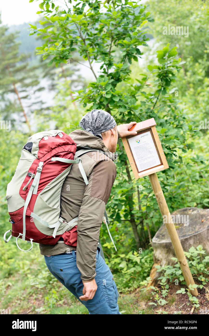 Hiker reading sign Stock Photo - Alamy
