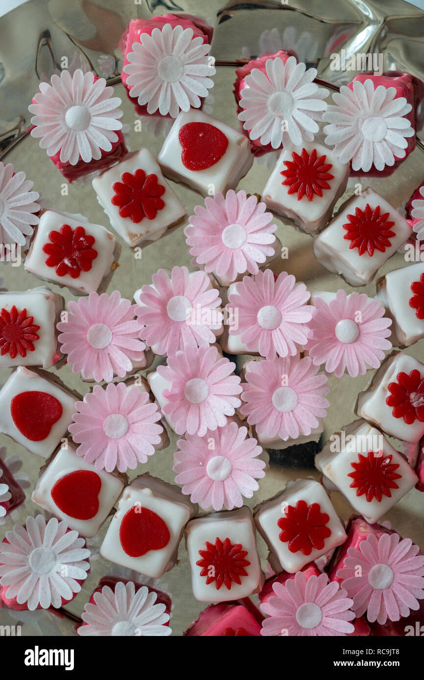 Colorful petit fours with flower decoration Stock Photo - Alamy