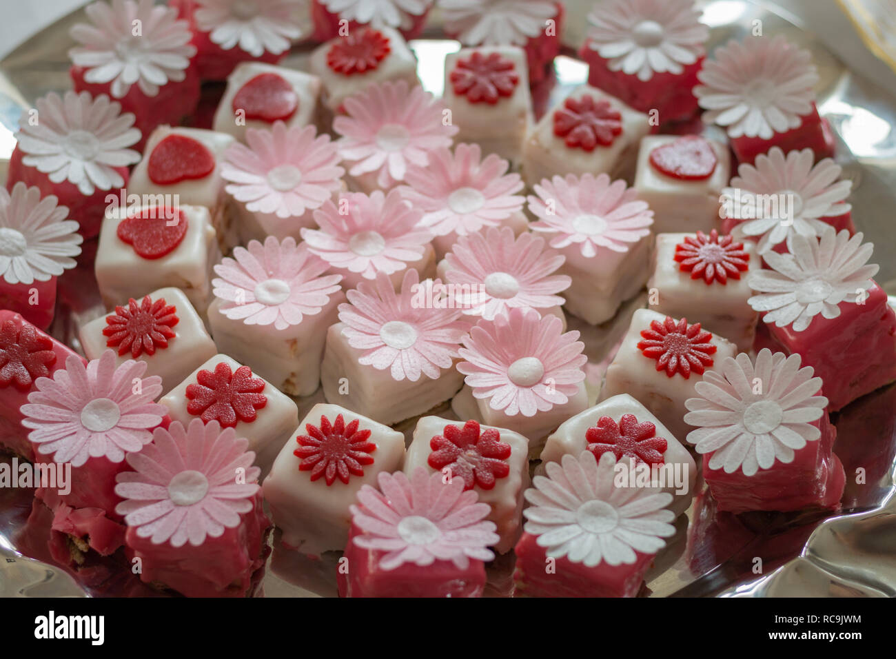 Colorful petit fours with flower decoration Stock Photo - Alamy