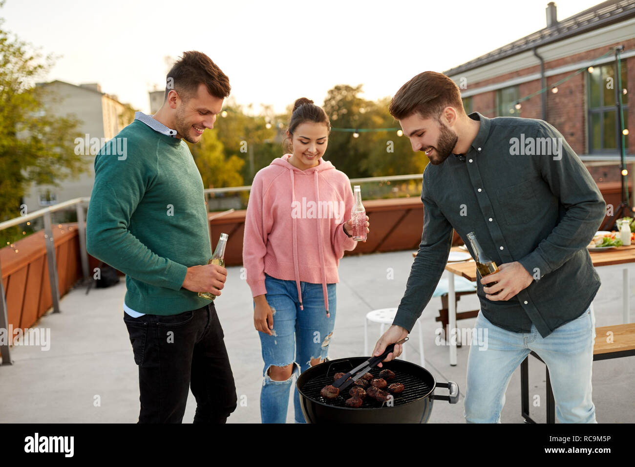 happy friends having bbq party on rooftop Stock Photo - Alamy