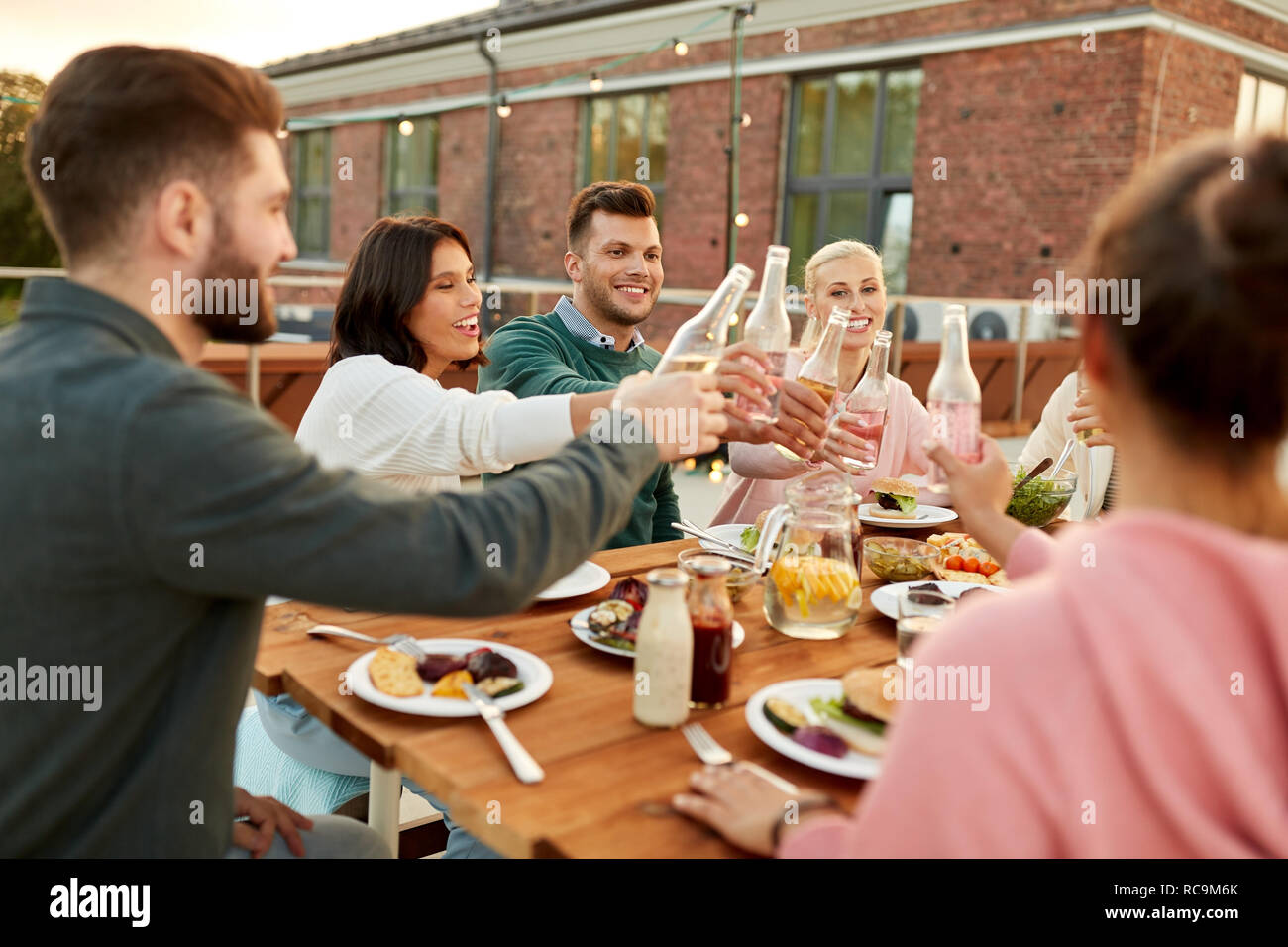 happy friends toasting drinks at rooftop party Stock Photo - Alamy