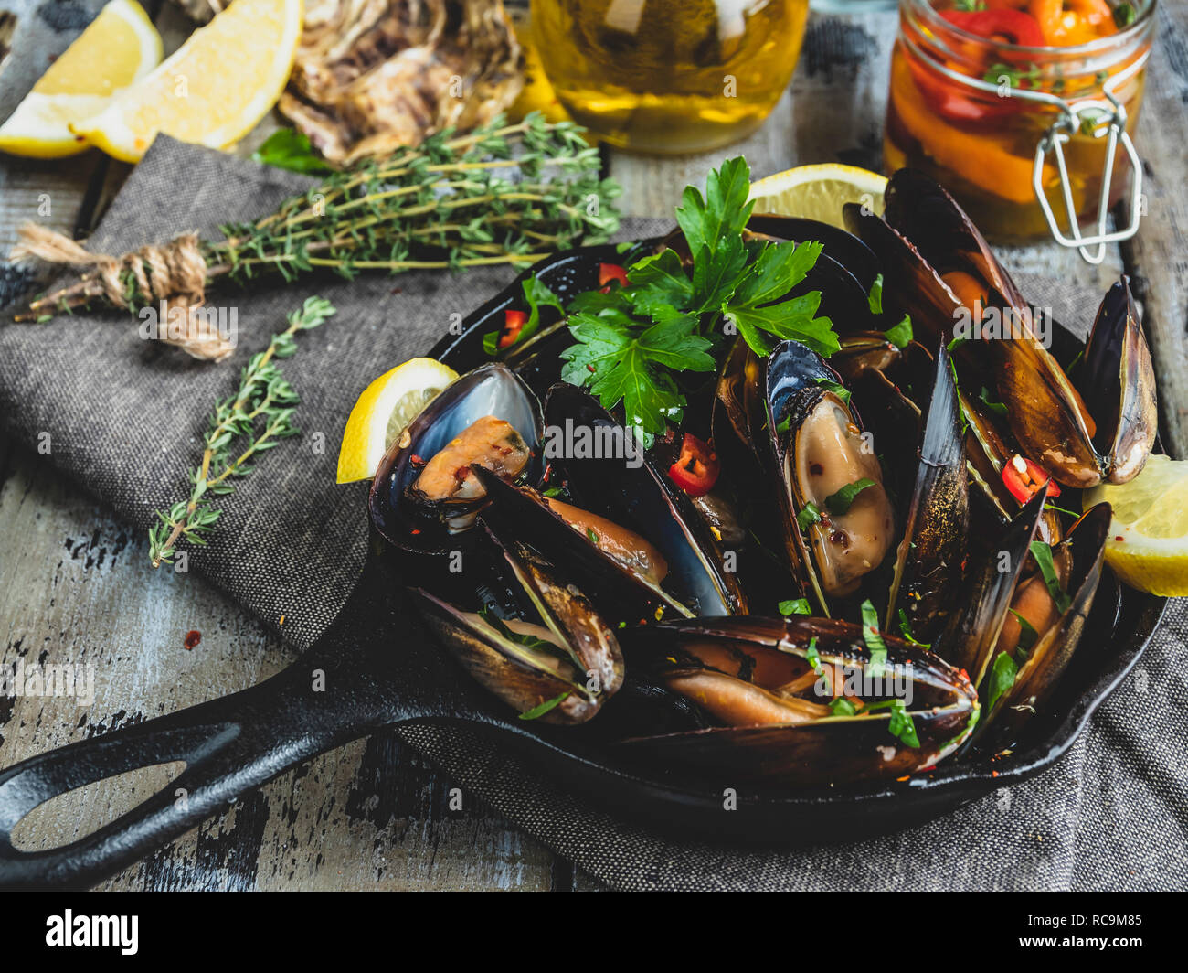 Cooked seafood clams mussels in the iron pan portion with lemon and ...