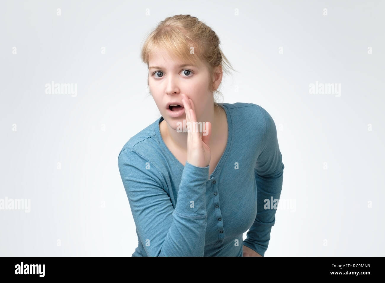 Secret, gossip concept. Pretty teenager whispering a secret behind her ...