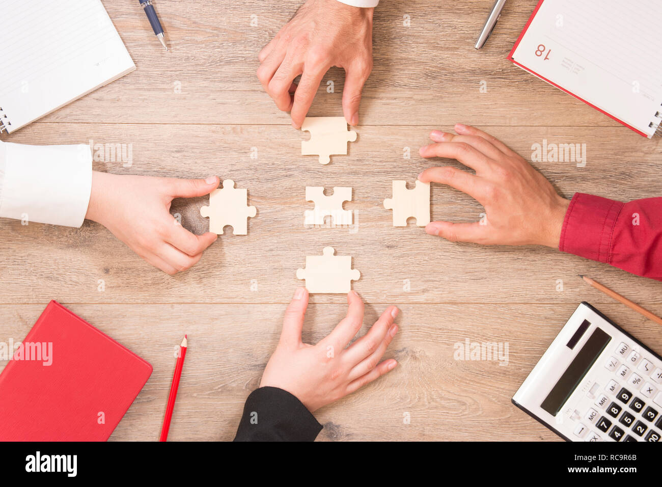 team completes the puzzle on the office desk Stock Photo - Alamy