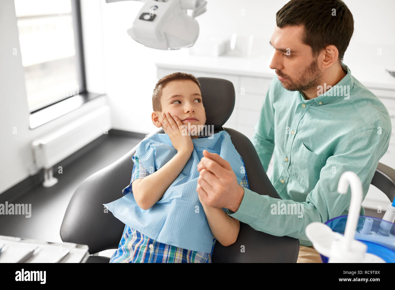 father supporting son at dental clinic Stock Photo - Alamy
