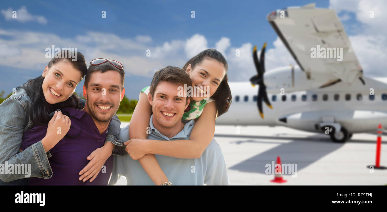 happy friends over plane on airfield background Stock Photo - Alamy