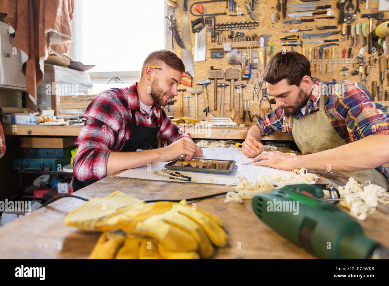 carpenters with tablet and blueprint at workshop Stock Photo - Alamy