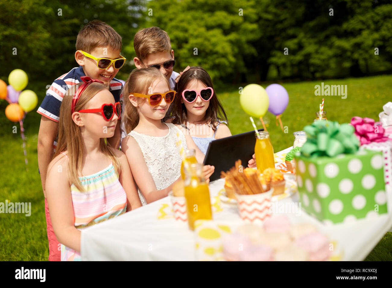 happy kids with tablet pc on birthday party Stock Photo - Alamy