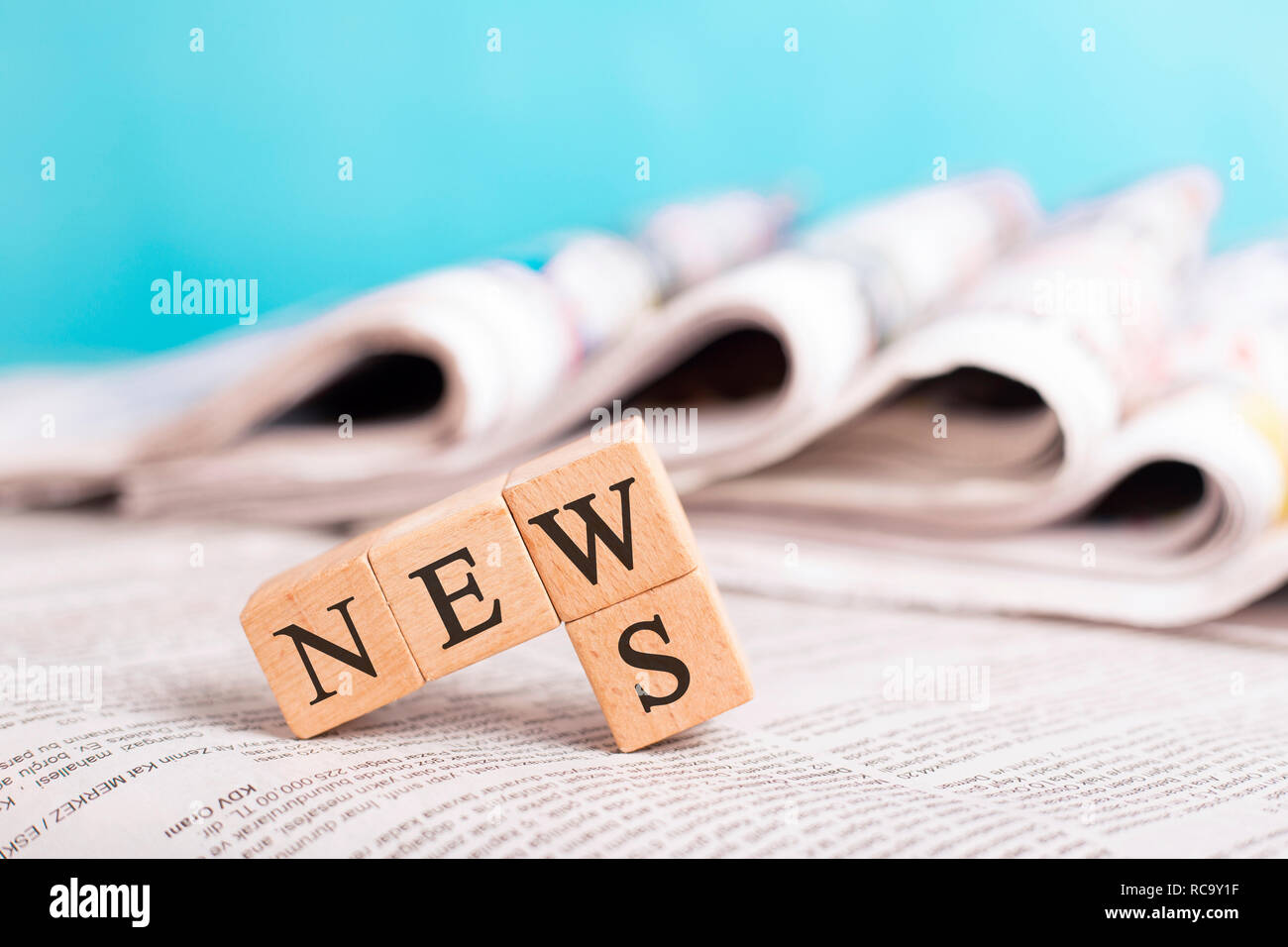 news word writing on cube front newspaper stack Stock Photo - Alamy