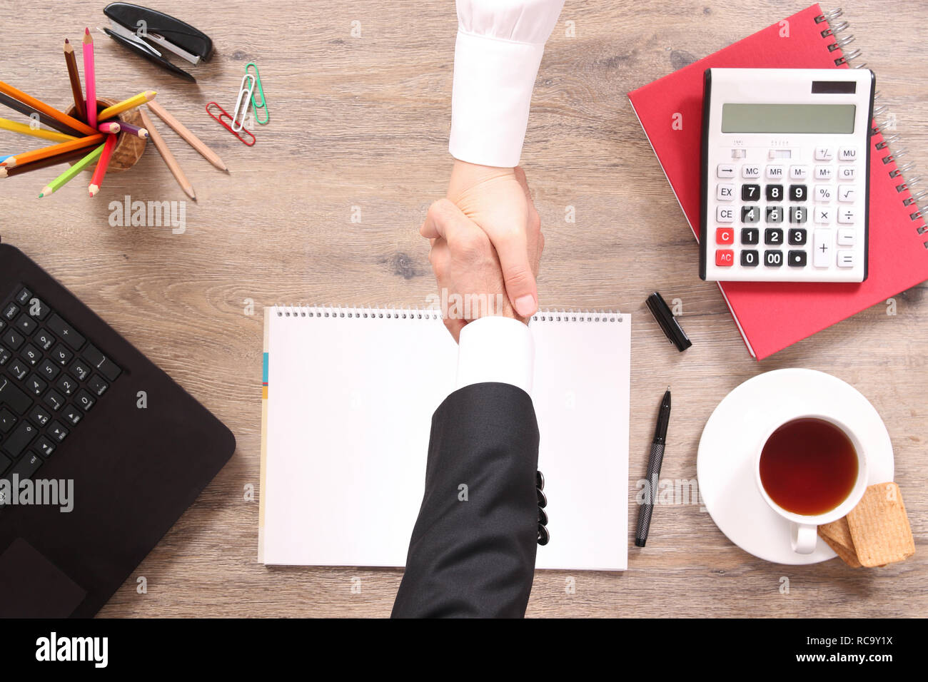 Shaking hands on the office desk man and woman Stock Photo - Alamy