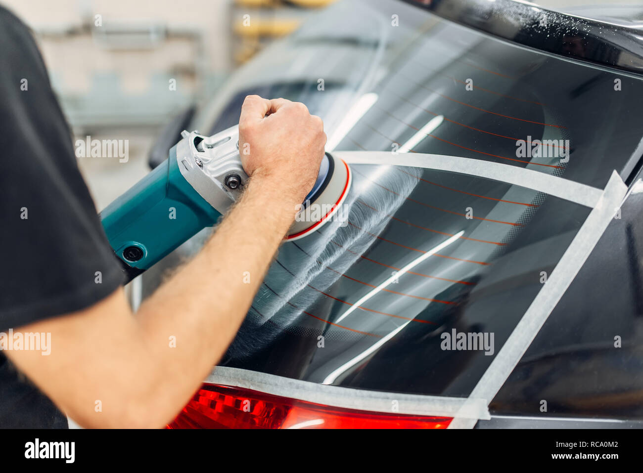 Worker with polishing machine removing the track from wiper blade on ...