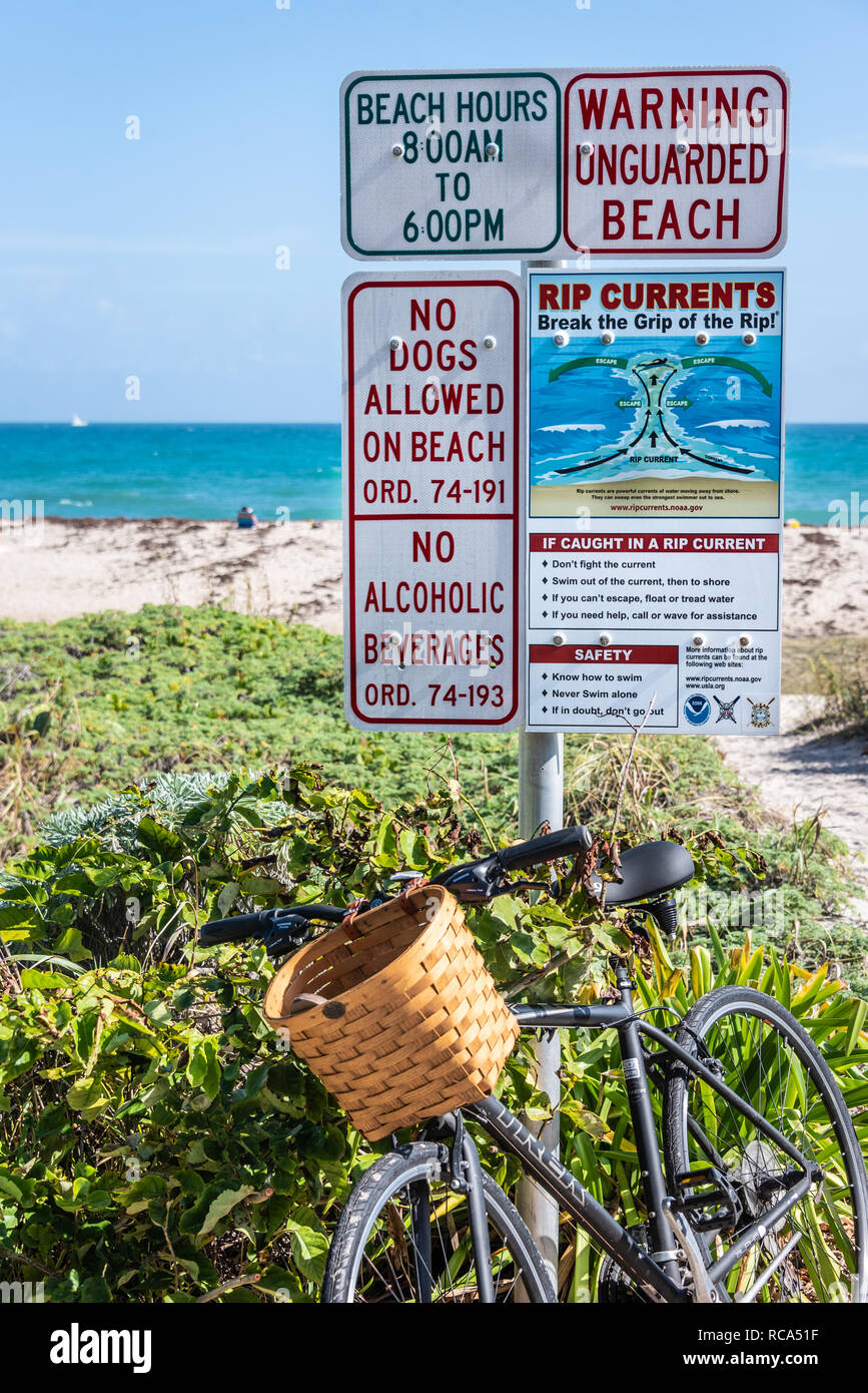 Beach bike leaning against beach warning signs in Palm Beach, Florida ...