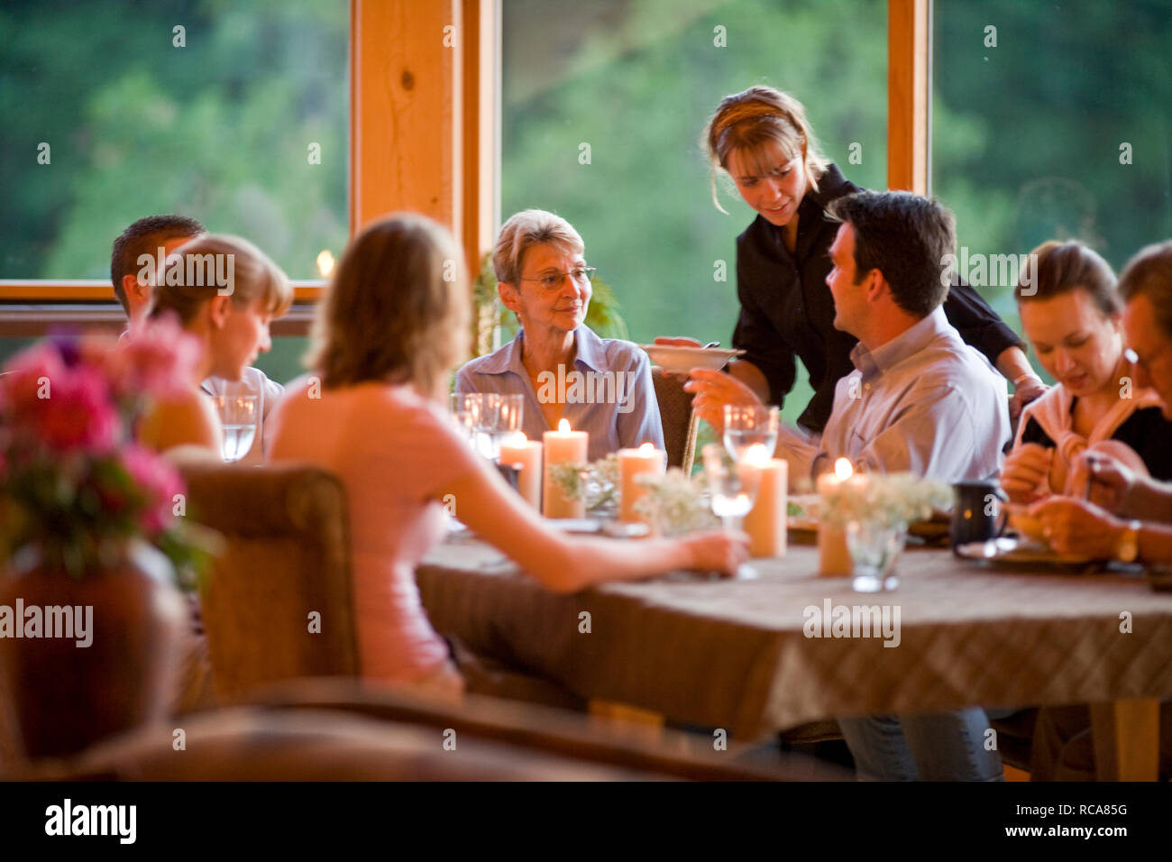 Waitress serving table at family dinner Stock Photo - Alamy