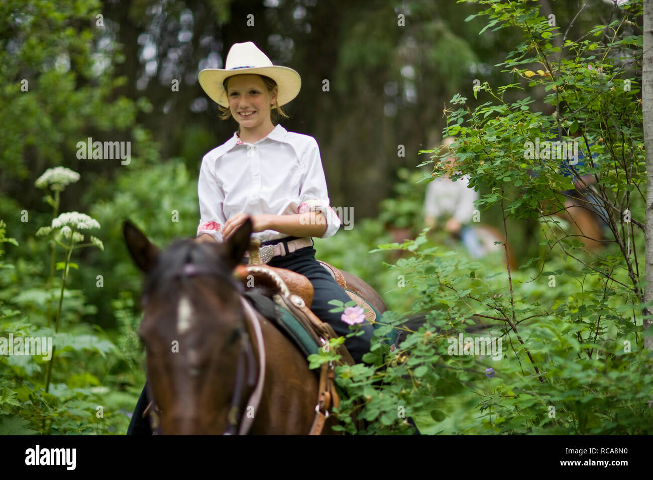 Girl riding horse through forest Stock Photo - Alamy