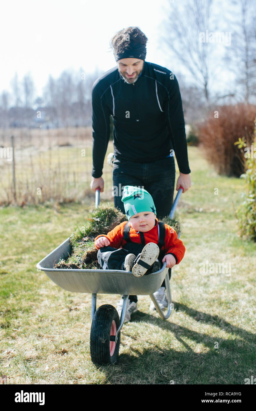 Father giving son ride in wheelbarrow Stock Photo - Alamy