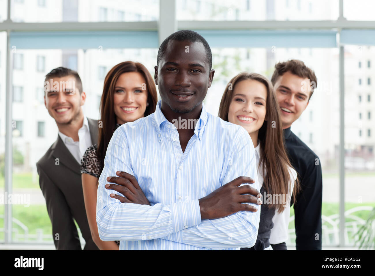Group of friendly businesspeople with male leader in front Stock Photo ...