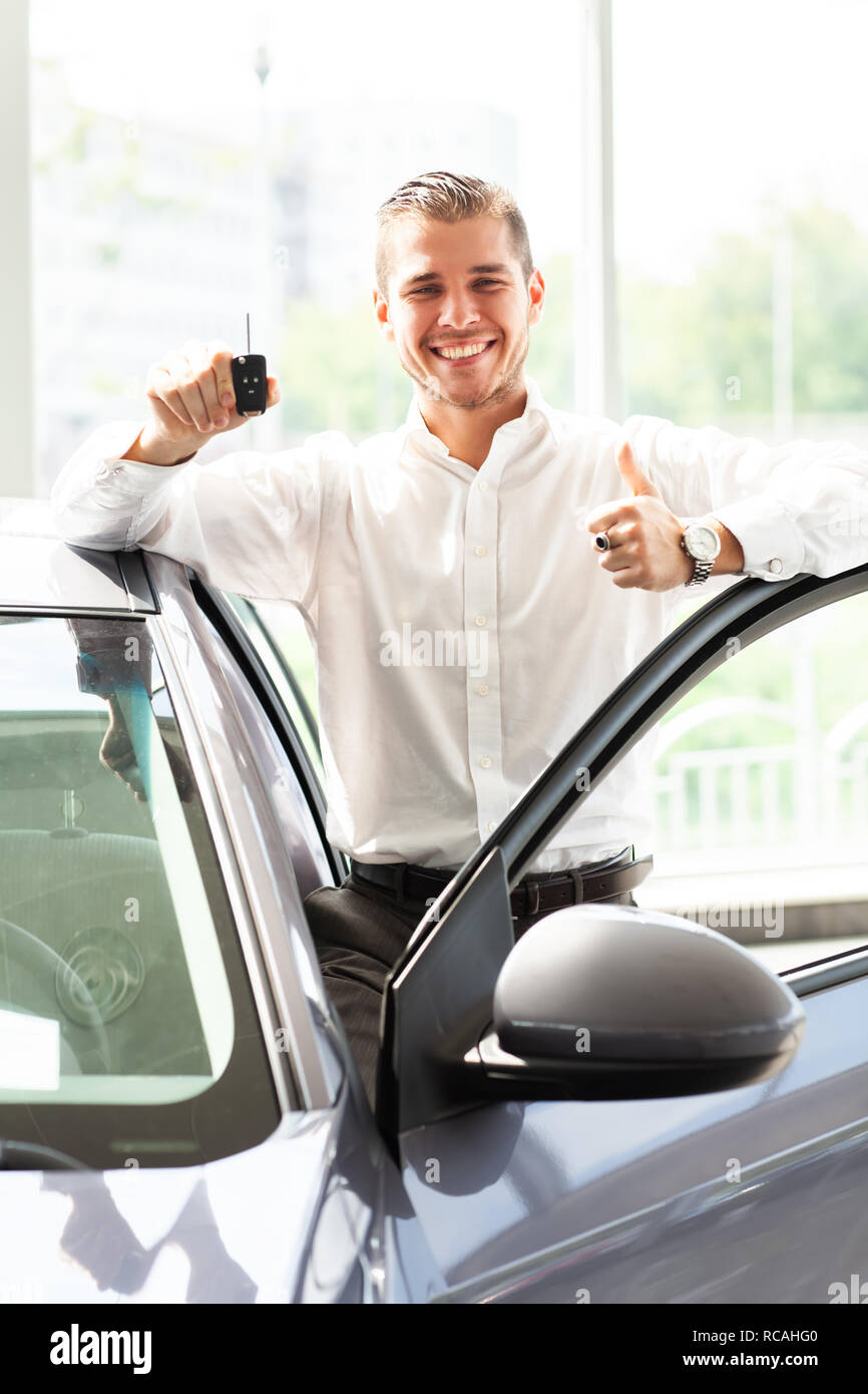 Happy car owner is showing thumbs up and his new car key Stock Photo ...