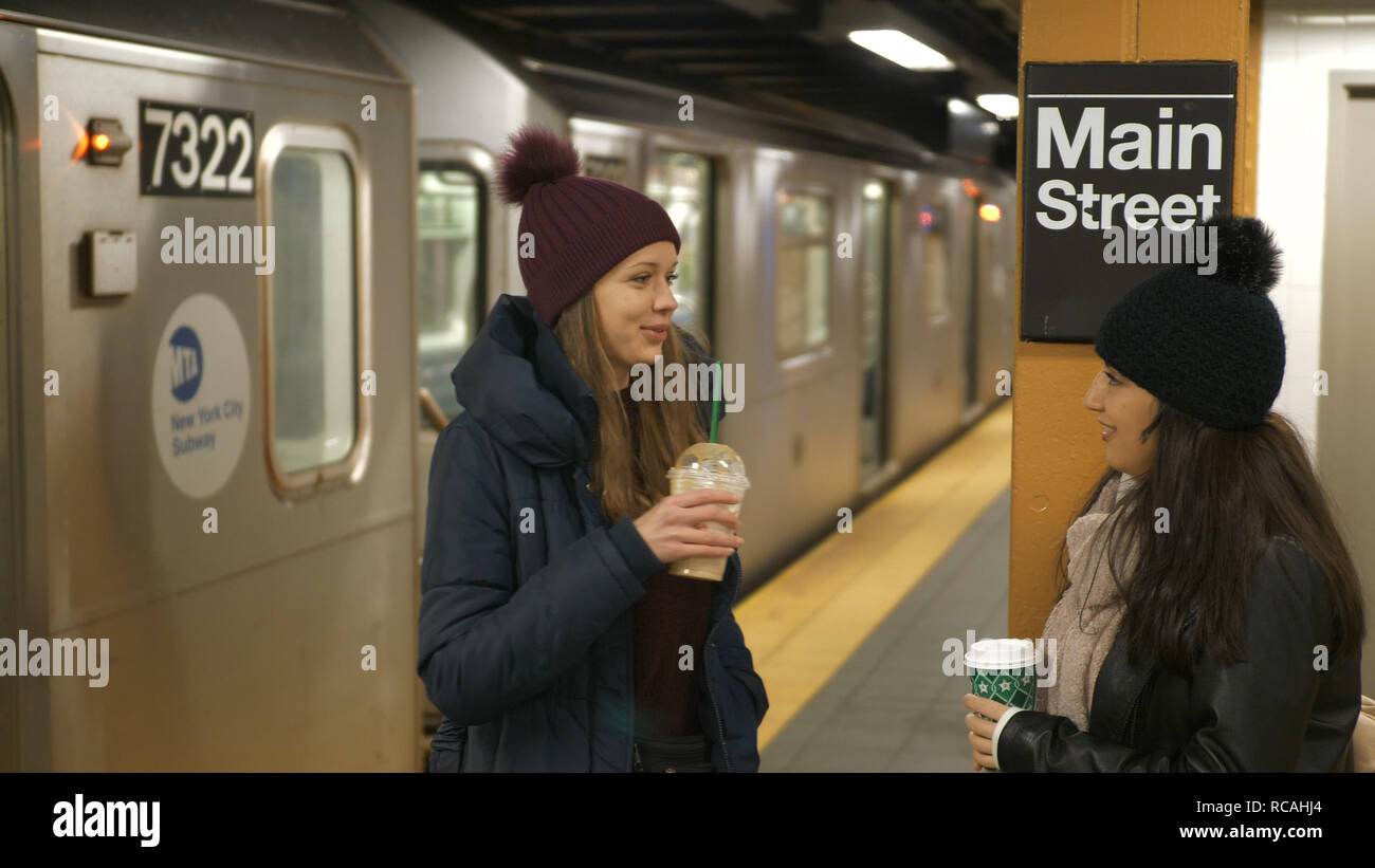 Two women on a platform of a New York subway station wait for their ...