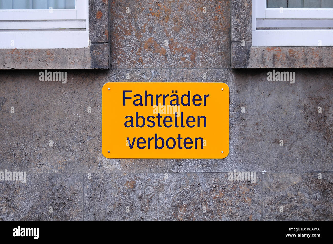 yellow prohibition sign at a facade with german inscription: parking of ...