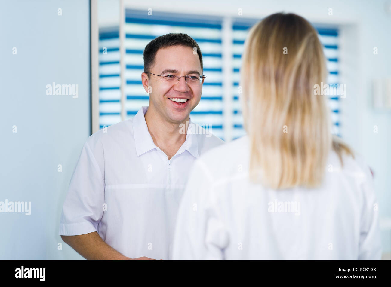 Doctor talking and laughing with his nurse assistant Stock Photo - Alamy