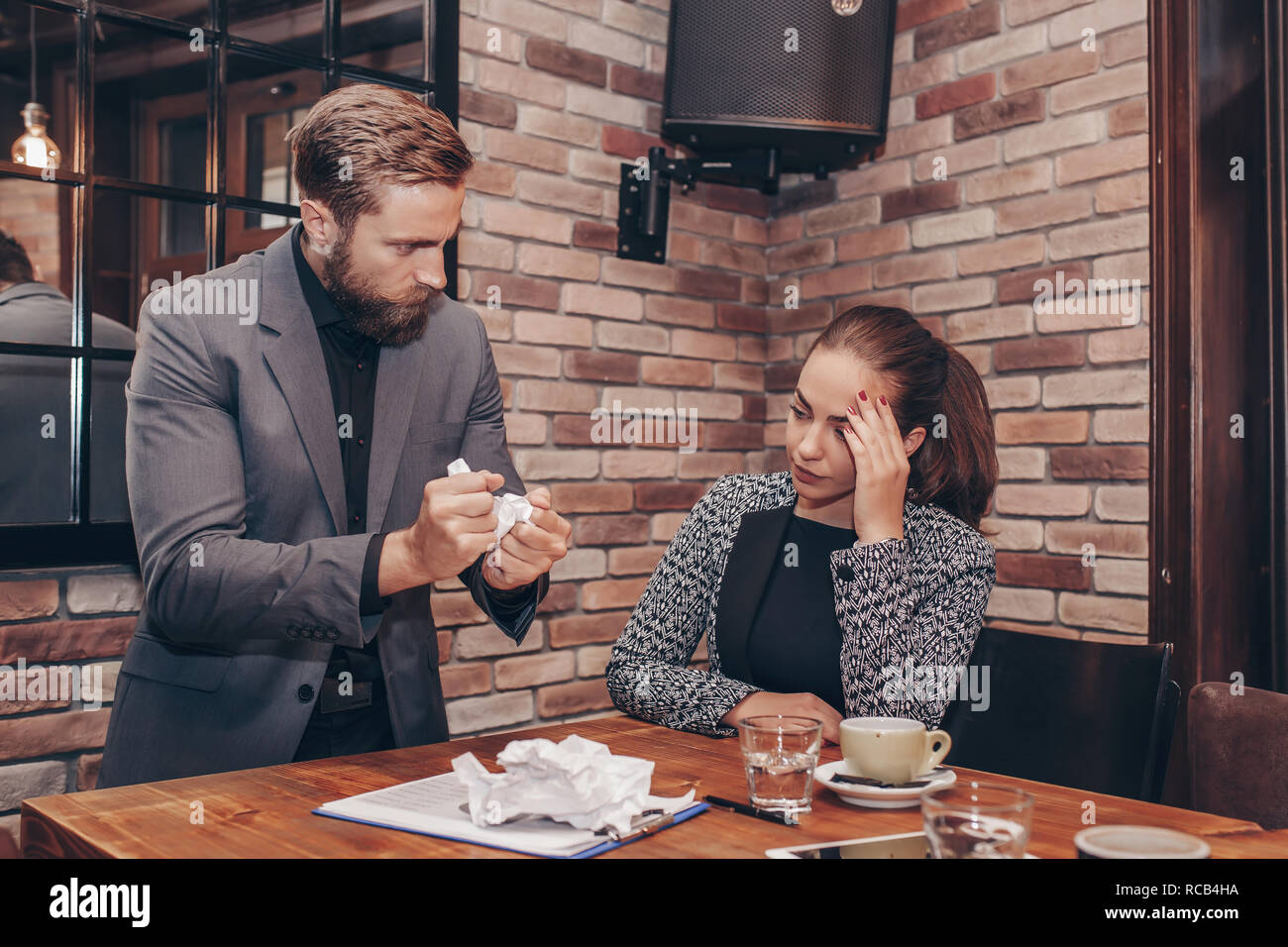 Woman suffering from stress because of angry male colleague holding ...